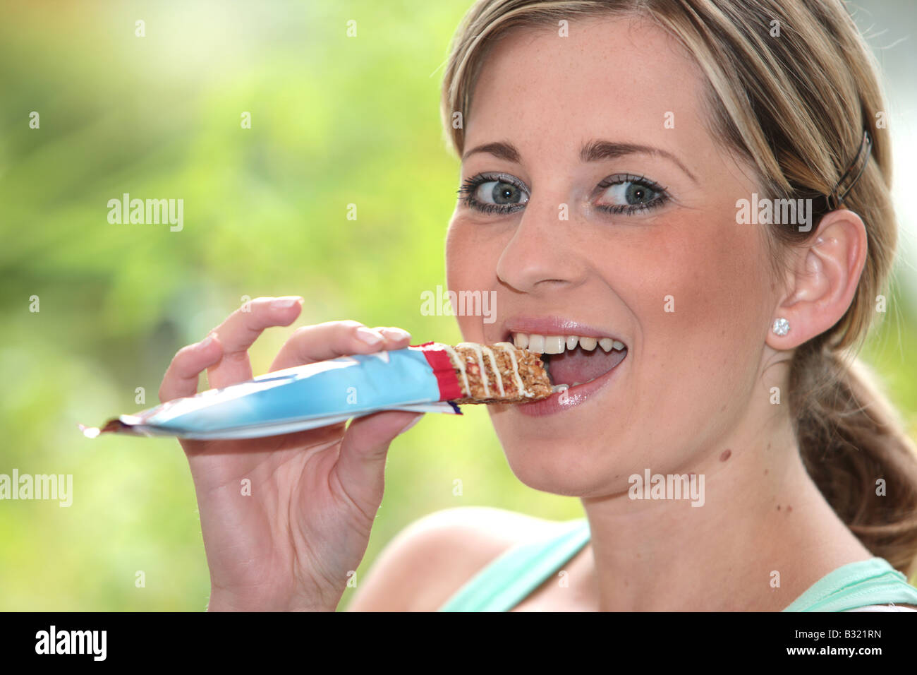 Young Woman Eating Cereal Bar Model Released Stock Photo - Alamy