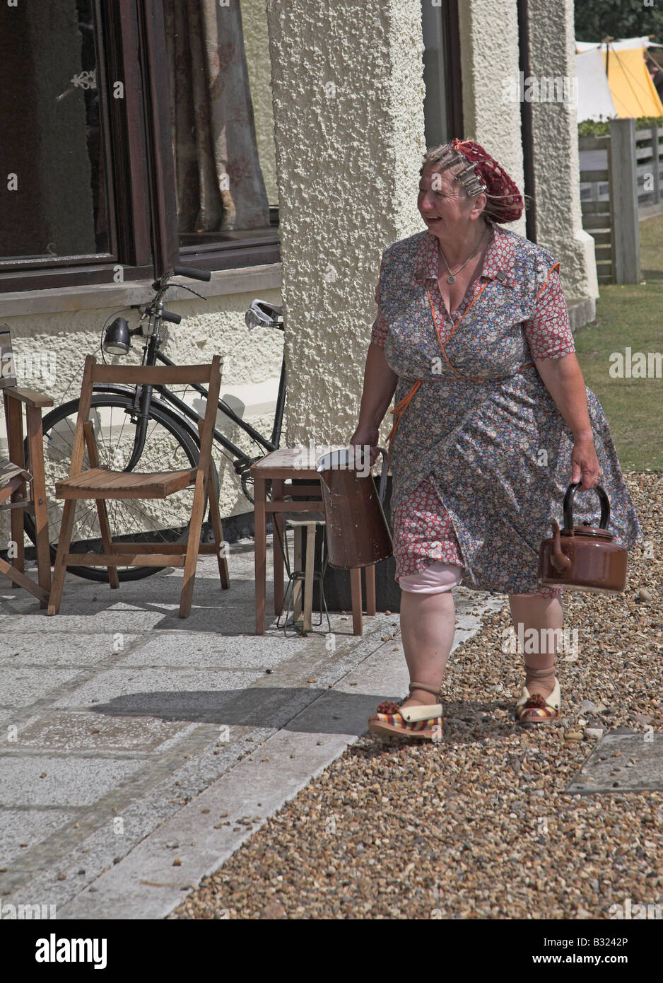 Woman in 1940s clothing carrying kettle Stock Photo - Alamy