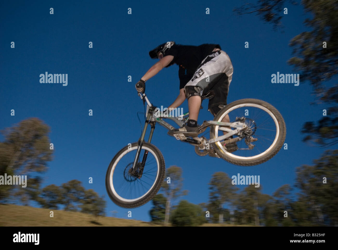 Downhill Mountain bike race extreme jump Stock Photo - Alamy