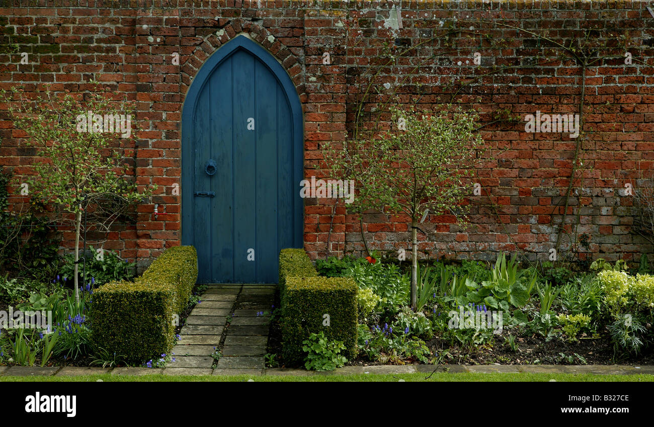 garden scene landscape with blue wooden door in spring months in rural ...