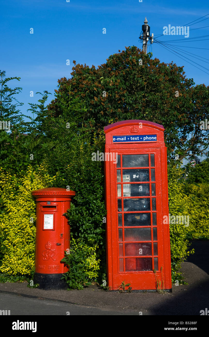 Traditional red George V pillar post box beside a classic red K6 ...