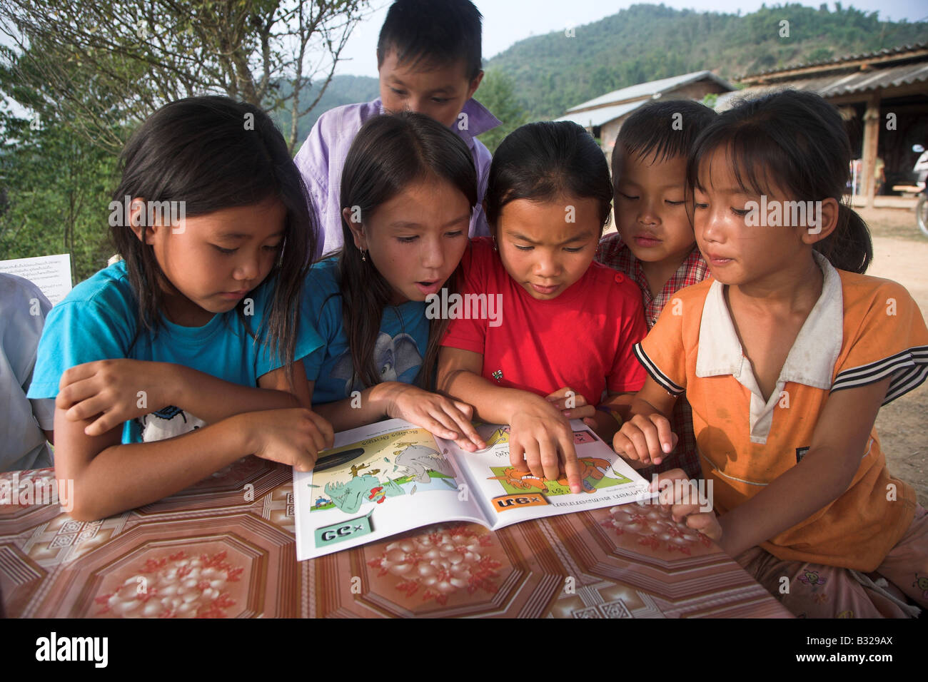 Local children reading an English to Lao learning book in the northern ...