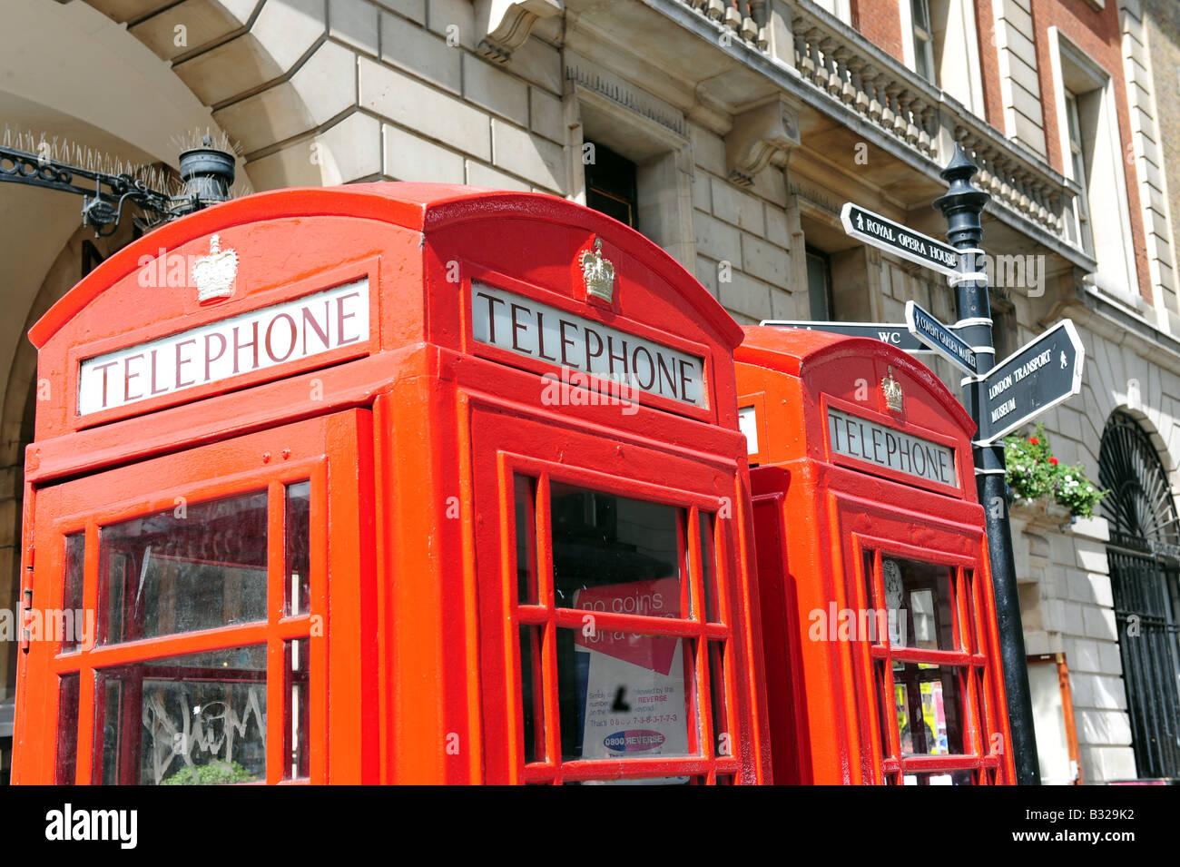 red telephone boxes in a street in london england Stock Photo - Alamy