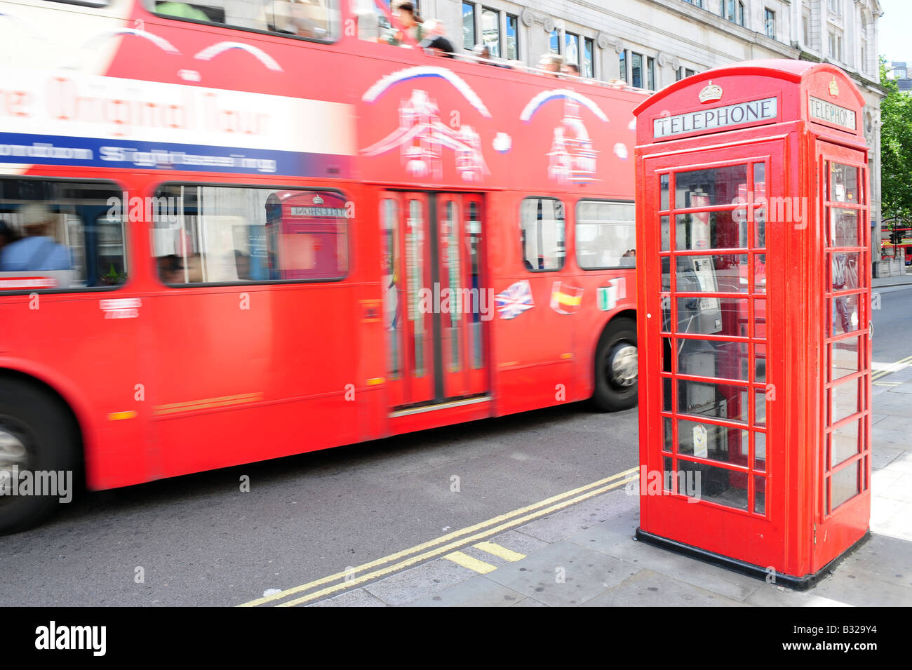 Red bus going past a red telephone box Stock Photo - Alamy