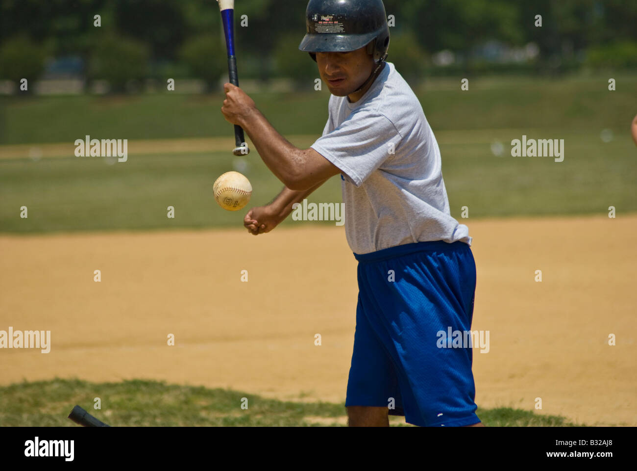 A man swings and hits a ball off the T at a Secial Olympics softball ...
