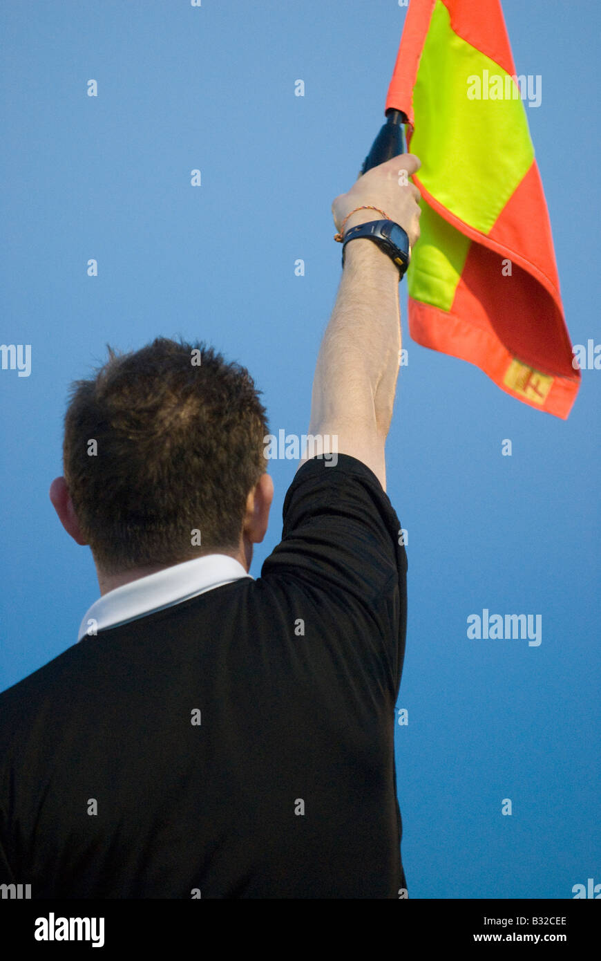 Linesman holds flag above head Stock Photo - Alamy