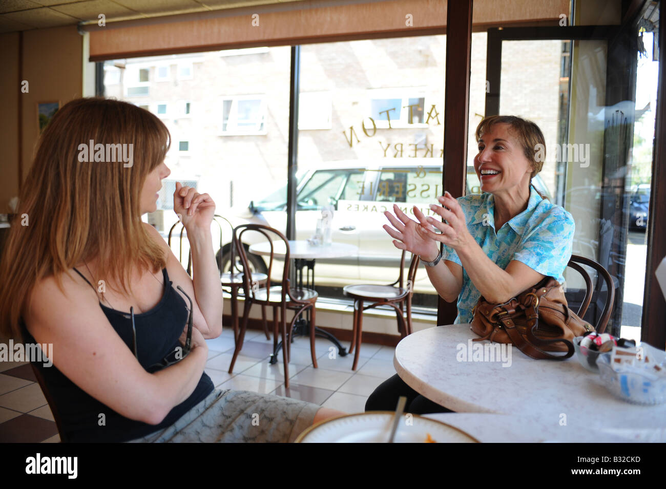 Women chatting in coffee shop Stock Photo - Alamy