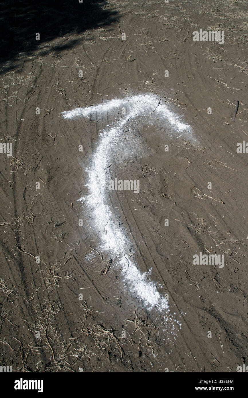 temporary chalk arrow on earth ground in field Stock Photo - Alamy