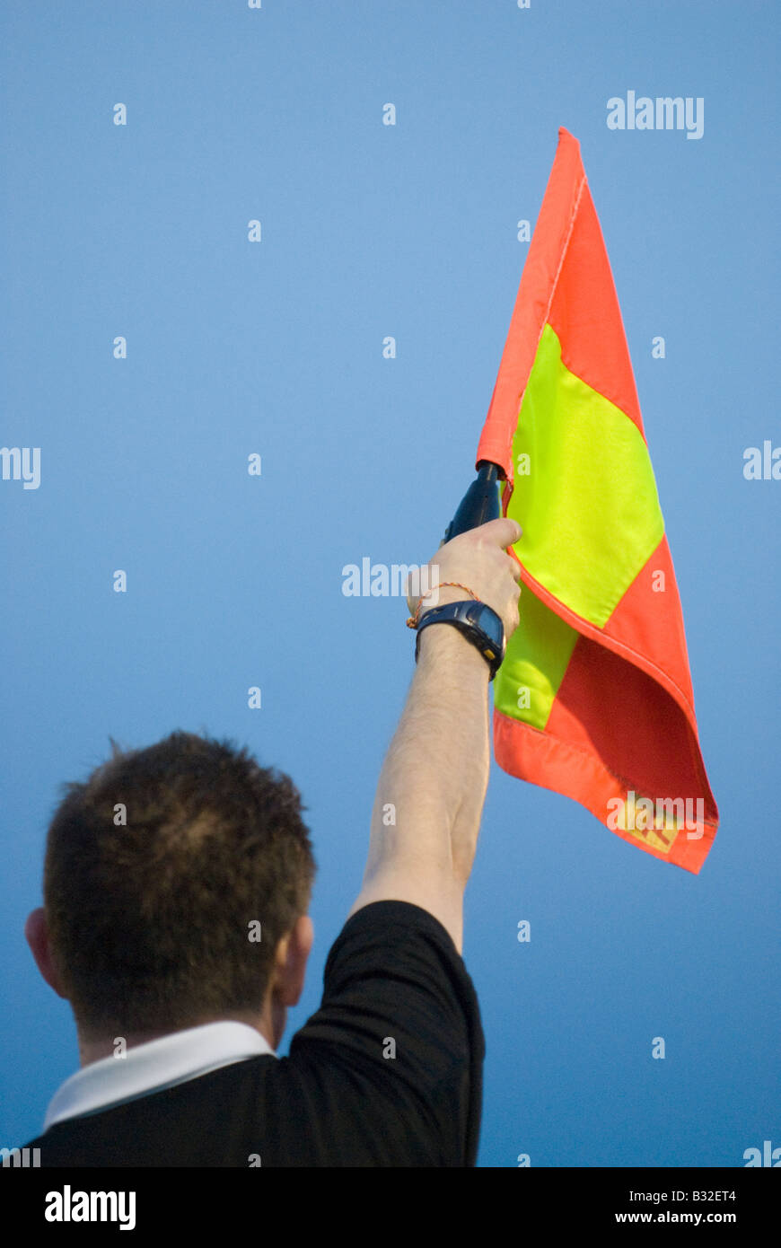 Linesman holds flag up Stock Photo - Alamy