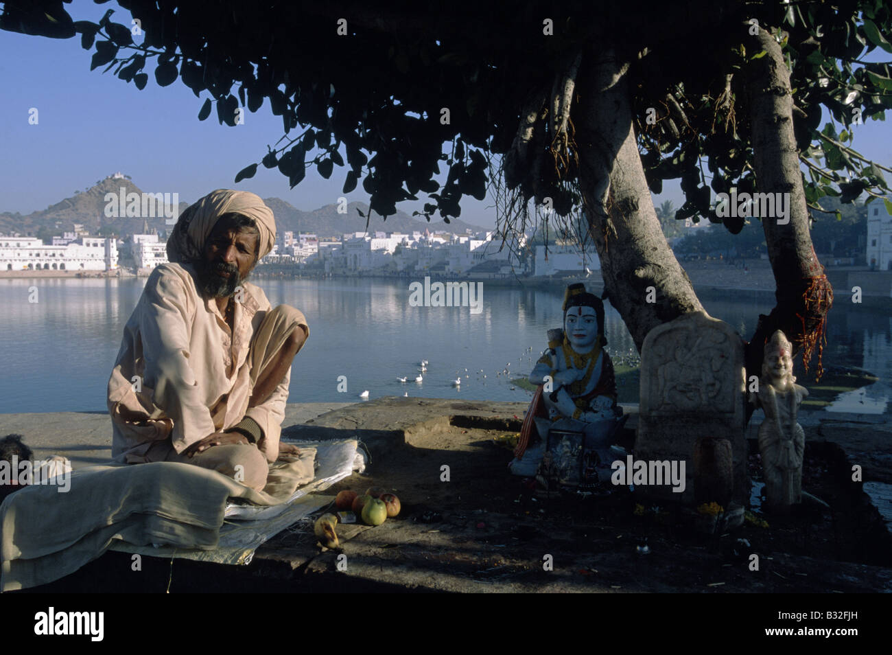 Eastern Rajasthan Holy man sadhu Seated by shrine By lake White washed ...