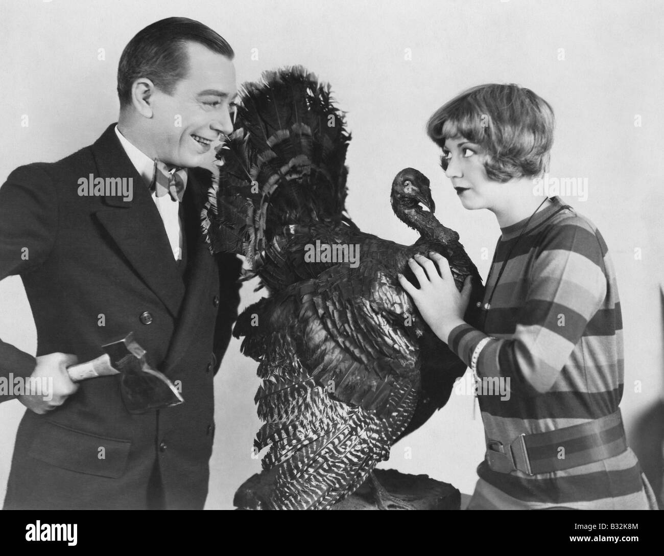 Woman protecting turkey from man with hatchet Stock Photo - Alamy