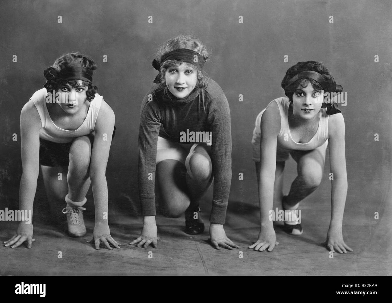 Portrait of three female runners in starting position Stock Photo - Alamy