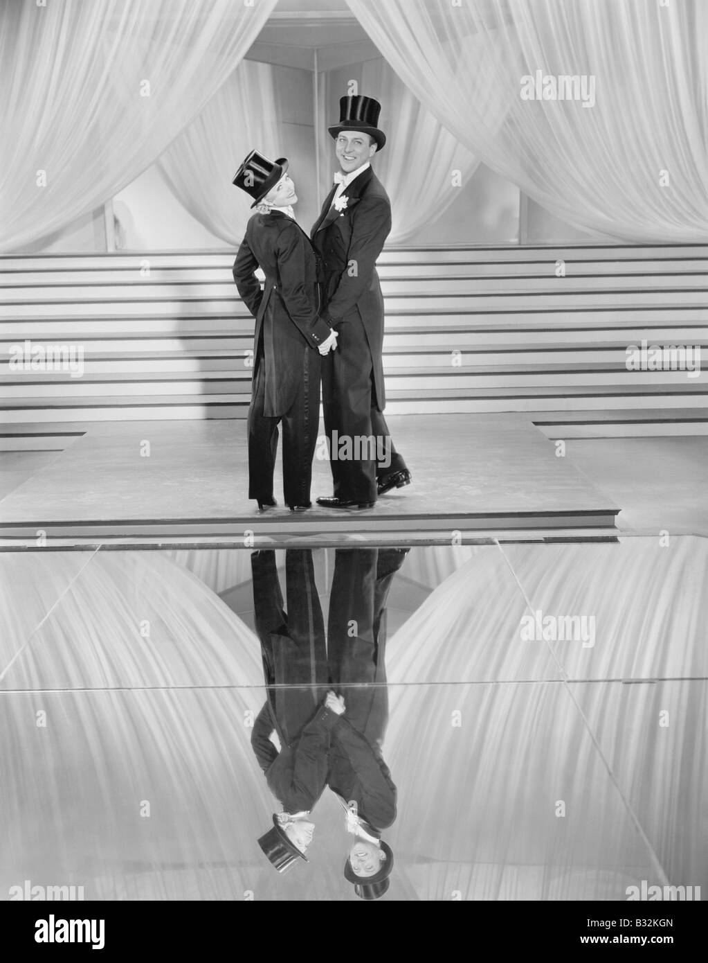Couple posing in tuxedos and reflection Stock Photo - Alamy
