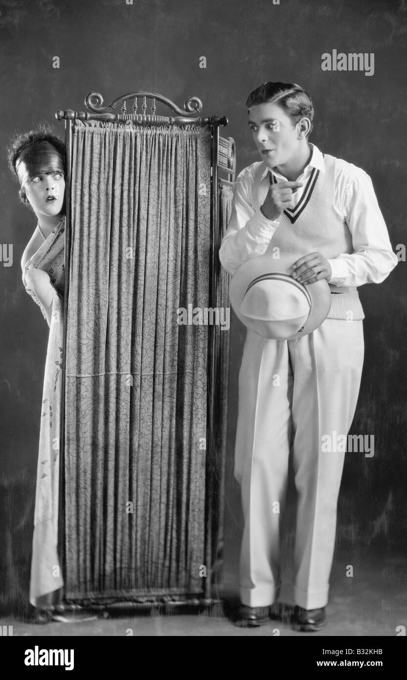 Man with woman changing behind screen Stock Photo - Alamy