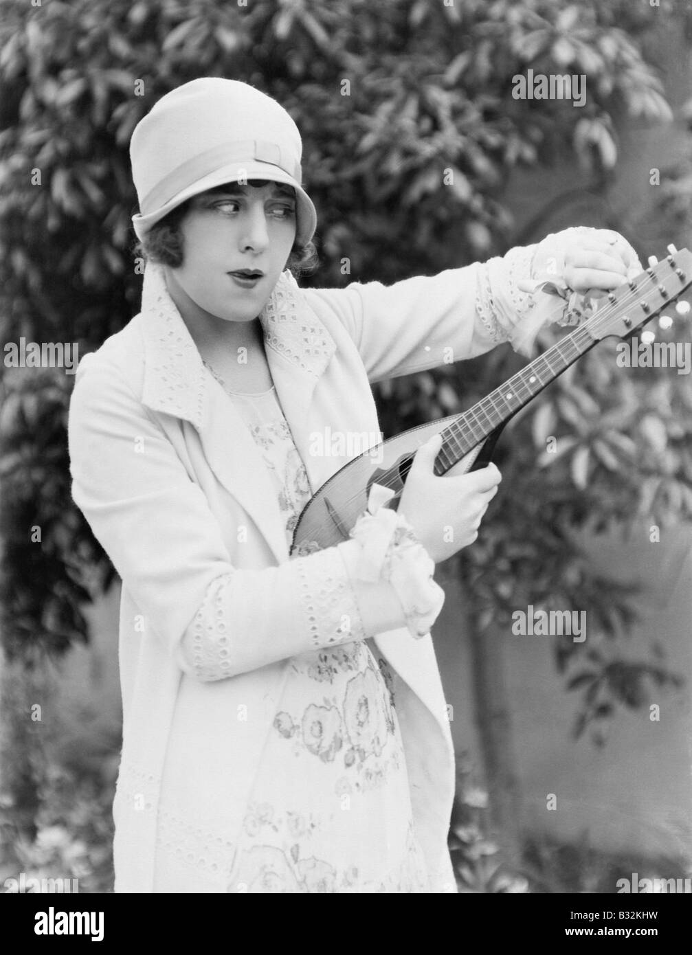 Woman tuning mandolin outside Stock Photo - Alamy