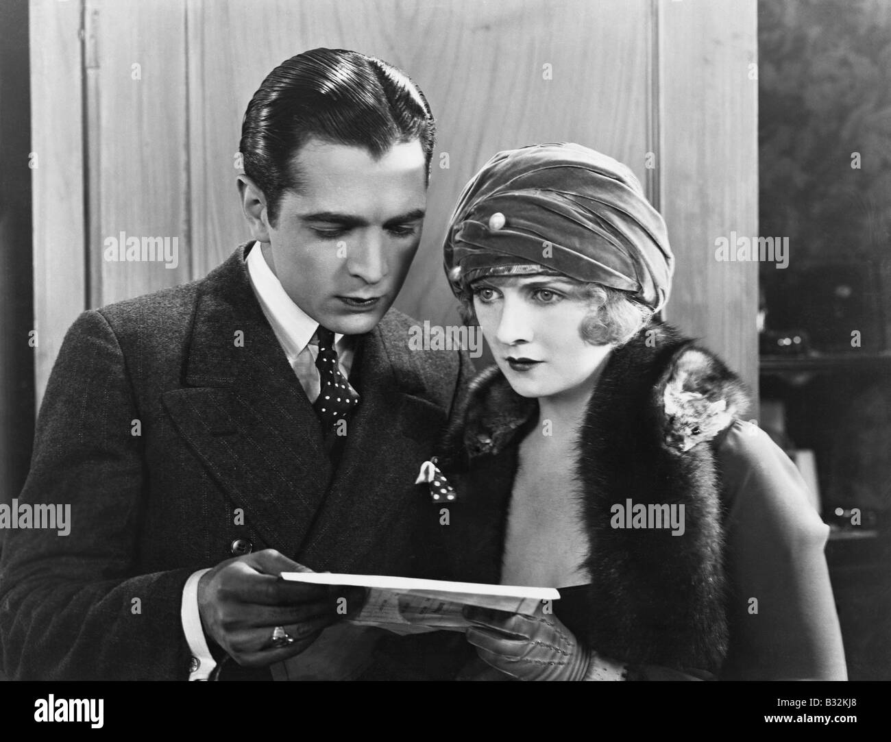 Couple reading document together Stock Photo - Alamy