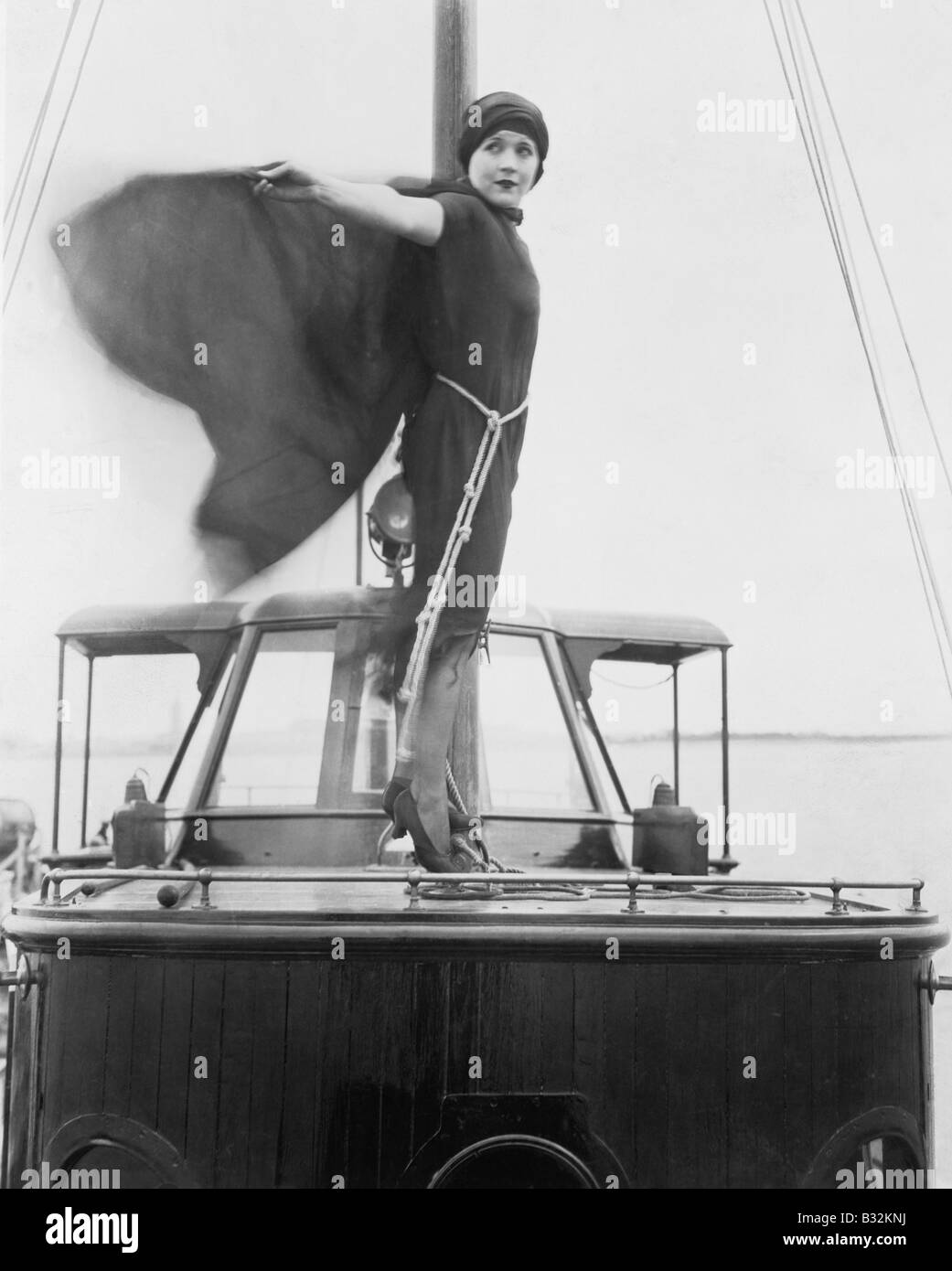 Woman standing on boat with cape fluttering in wind Stock Photo - Alamy