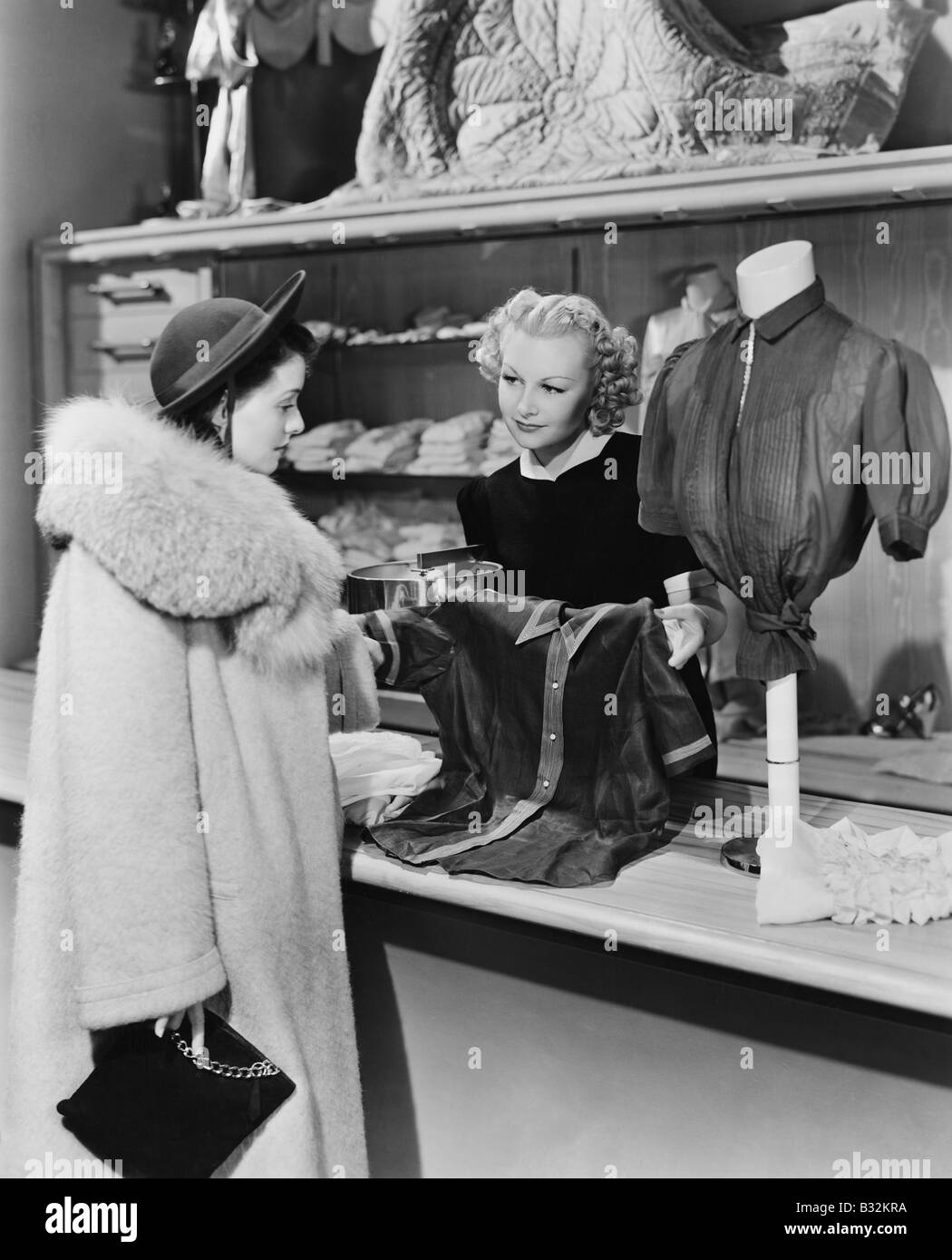 Customer and clerk in clothing store Stock Photo - Alamy