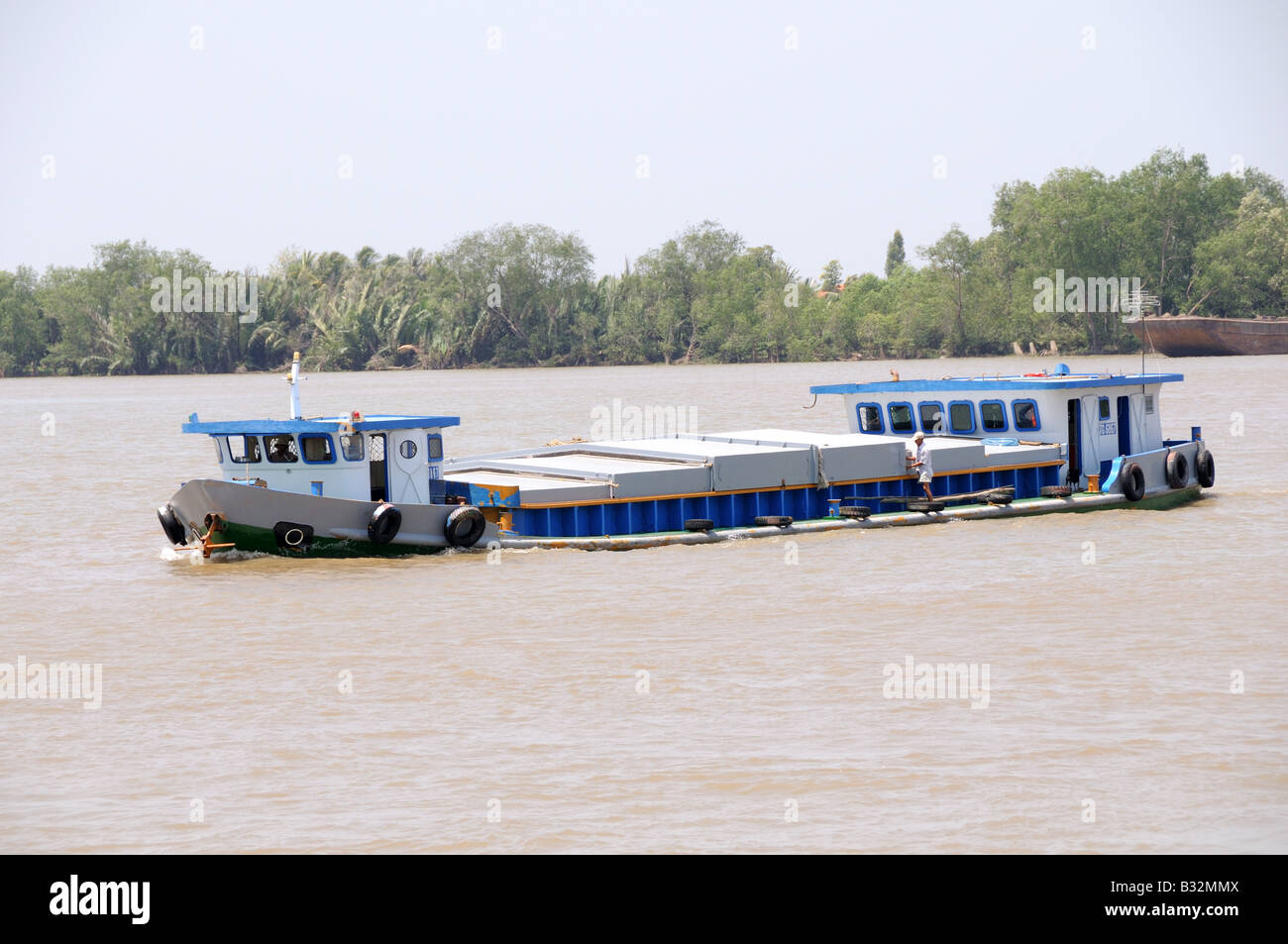 Building materials being transported by barge on the Mekong River ...