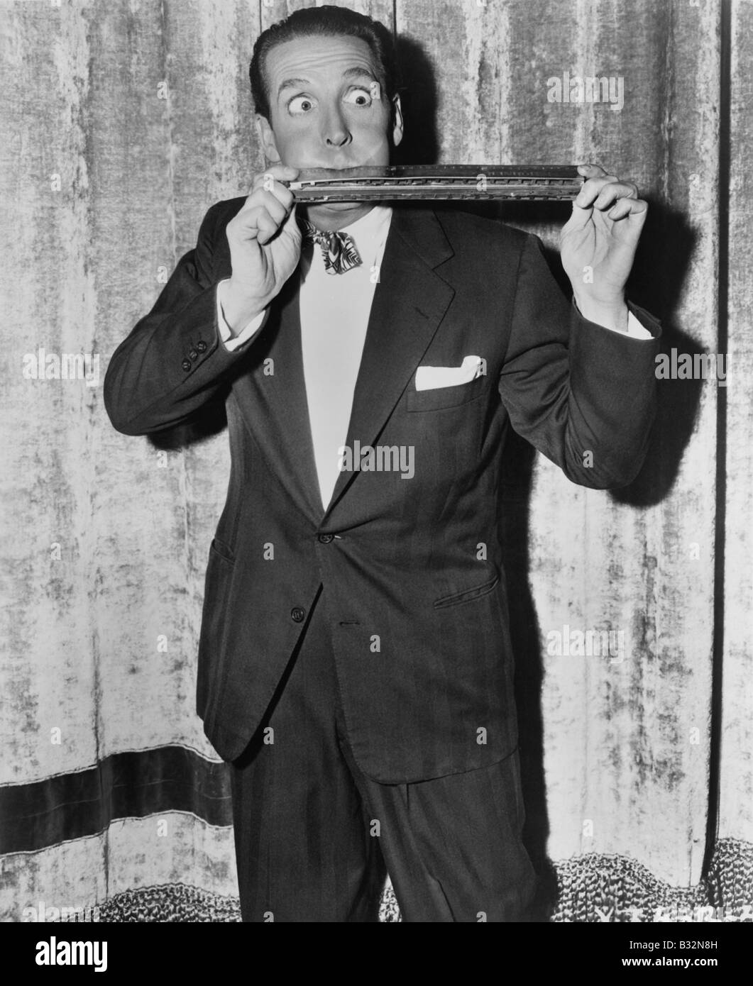 Portrait of man playing huge harmonica Stock Photo - Alamy