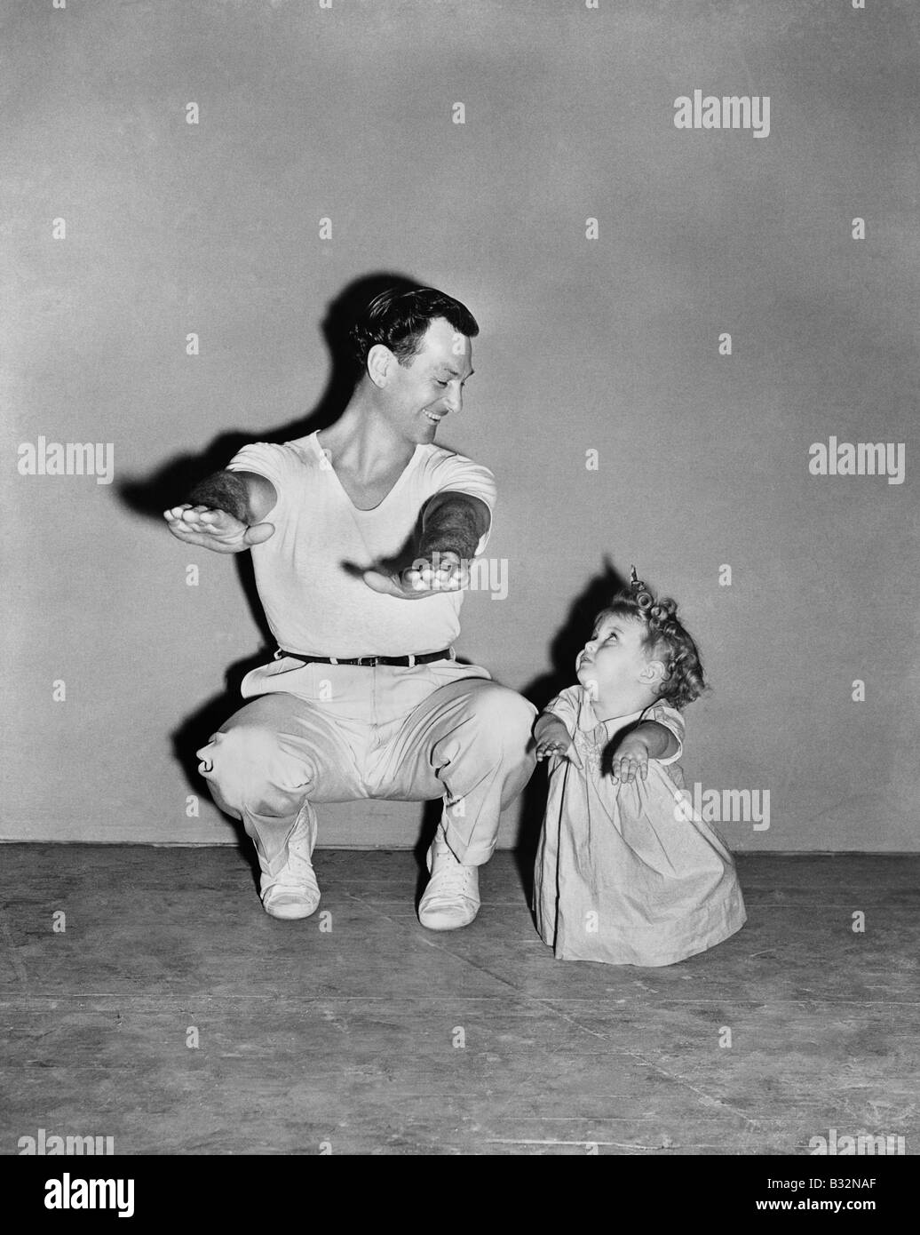 Baby girl imitating dad Stock Photo - Alamy