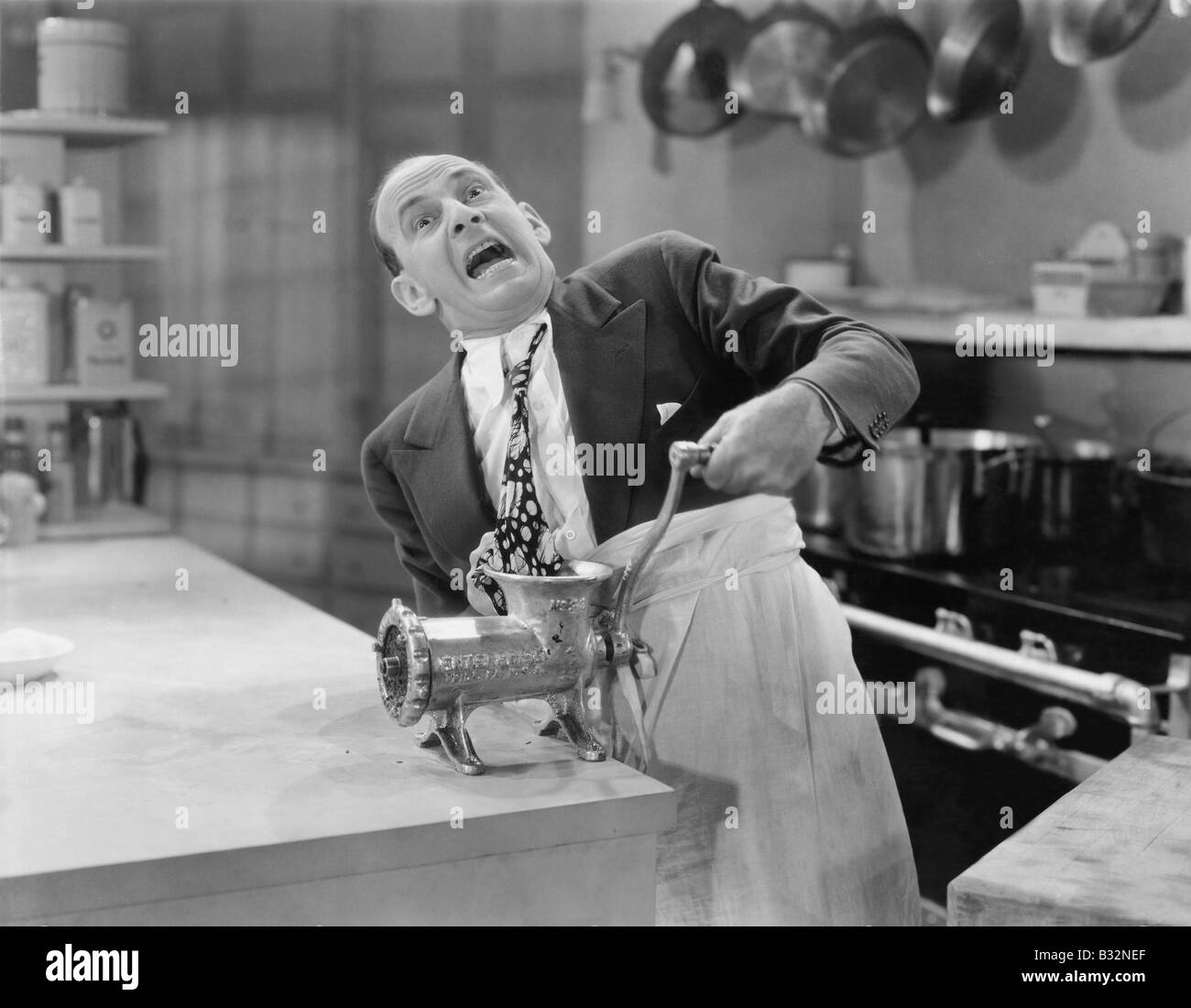 Man with tie stuck in meat grinder Stock Photo - Alamy