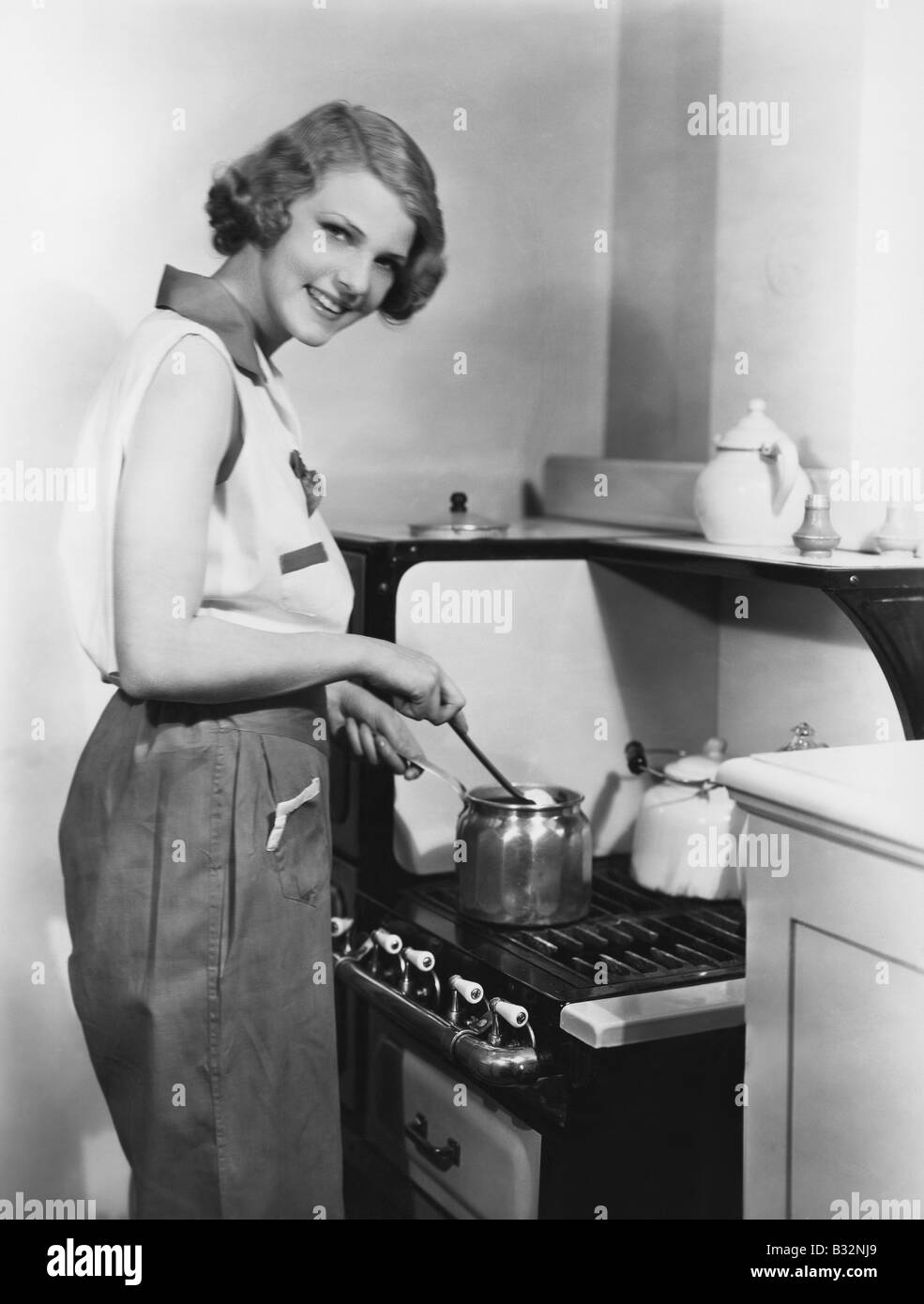 Smiling woman cooking food Black and White Stock Photos & Images - Alamy