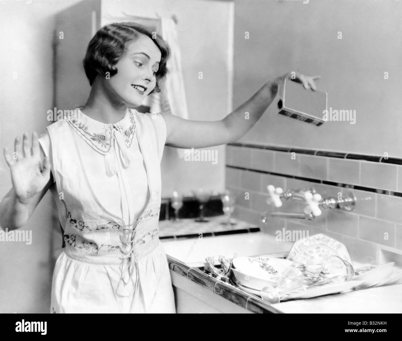 Woman pouring soap on dishes Stock Photo - Alamy