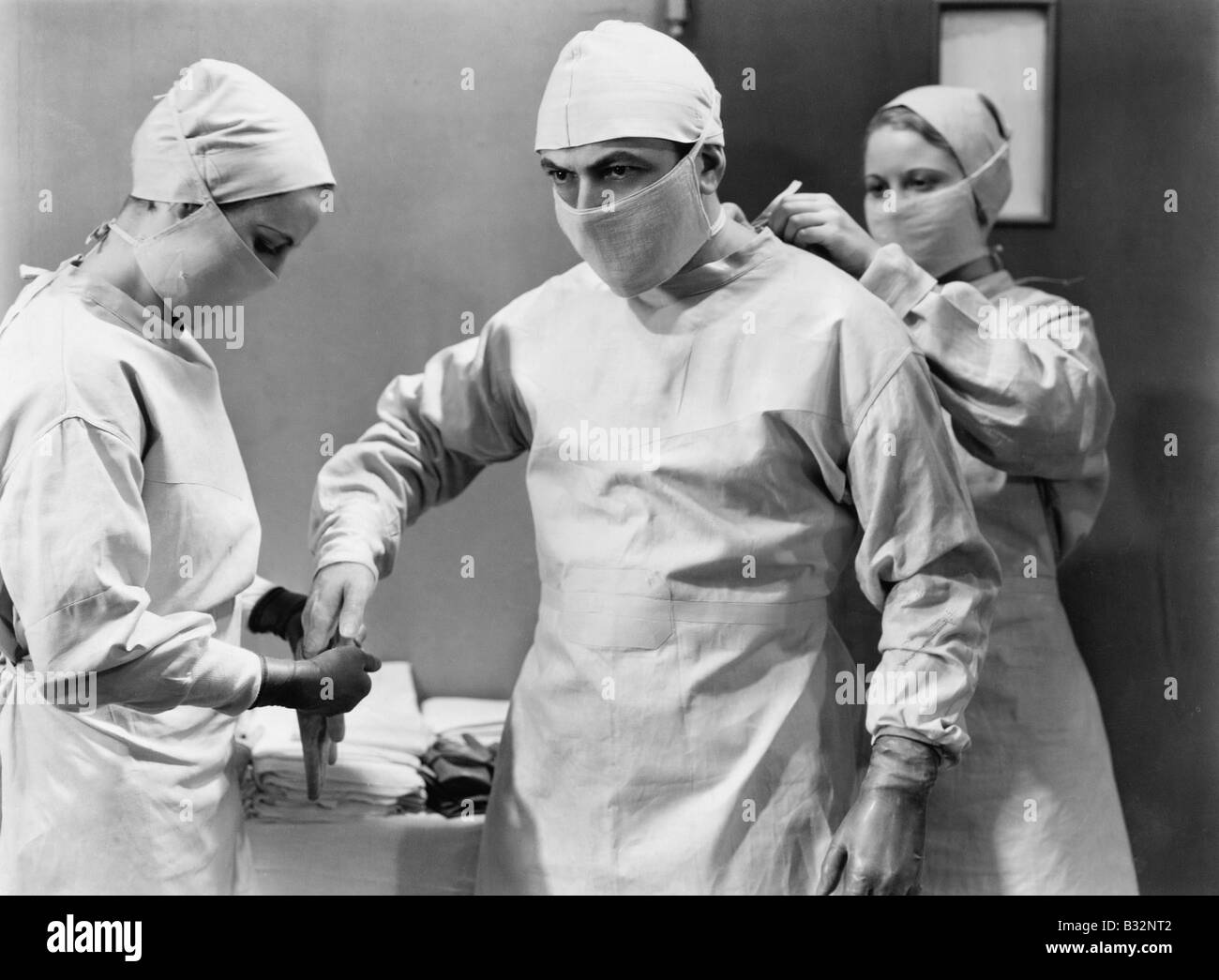 Women preparing doctor for surgery Stock Photo - Alamy