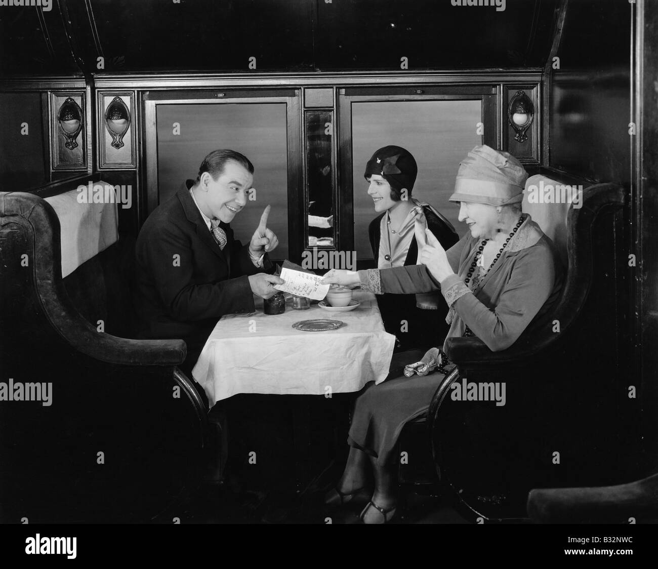Smiling woman dining table Black and White Stock Photos & Images - Alamy