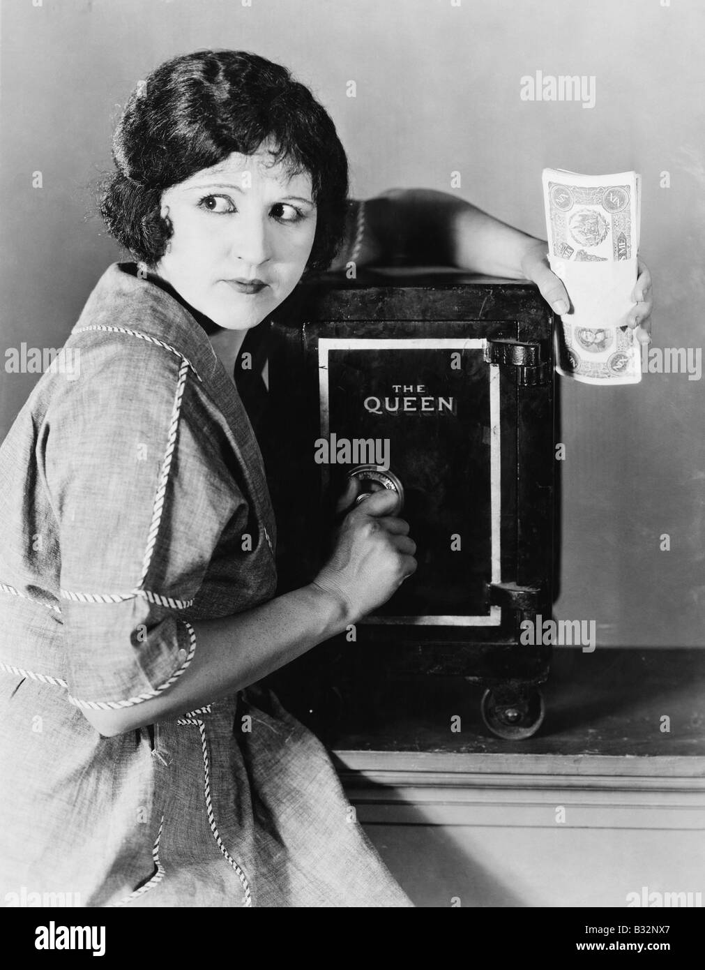 Woman with money and safe Stock Photo - Alamy
