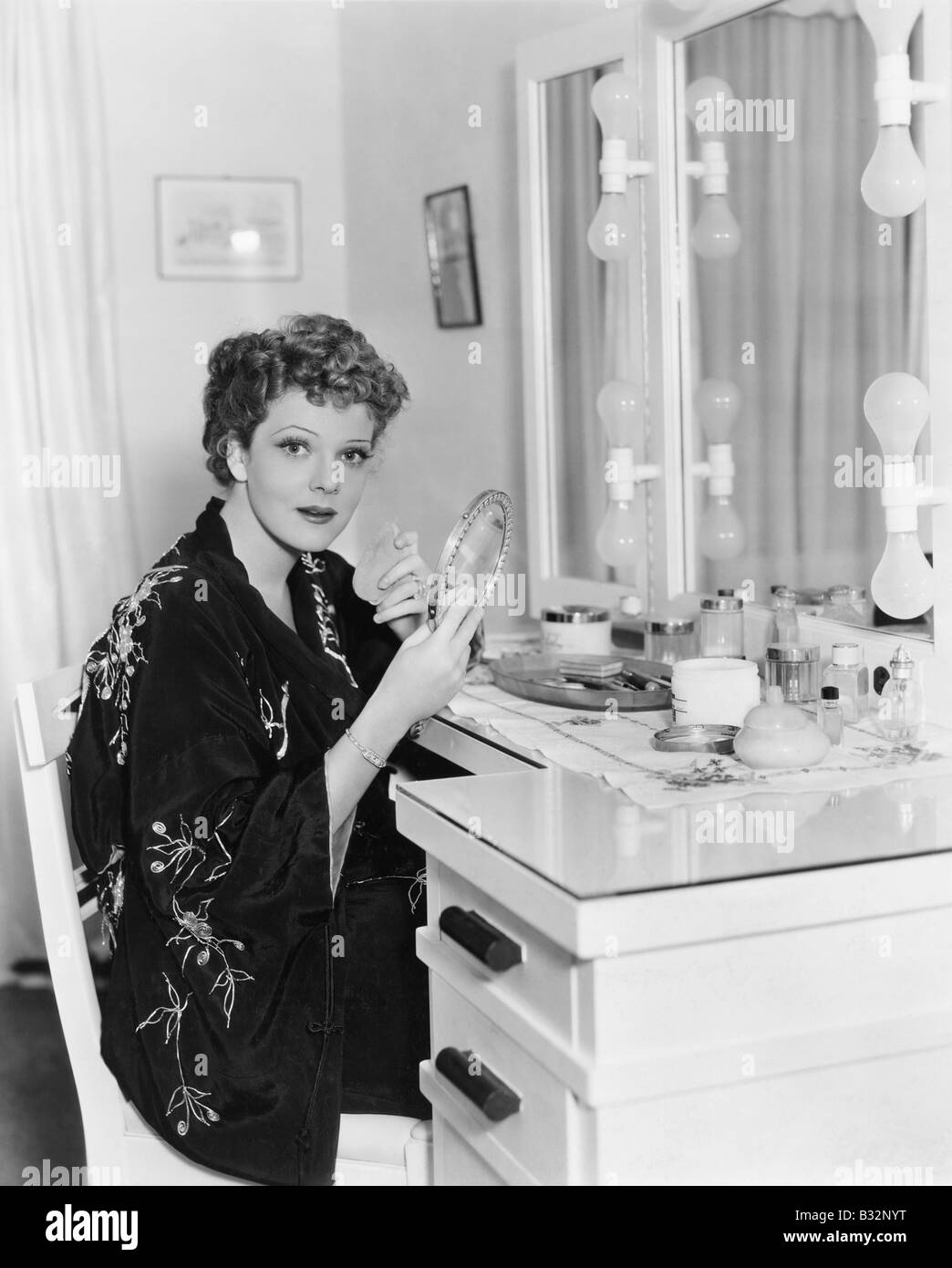 Portrait of woman at dressing table Stock Photo - Alamy