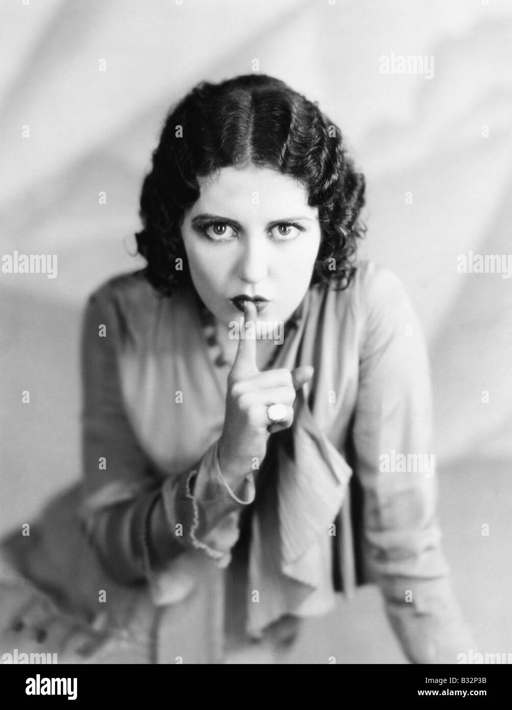 Portrait of woman shushing Stock Photo - Alamy