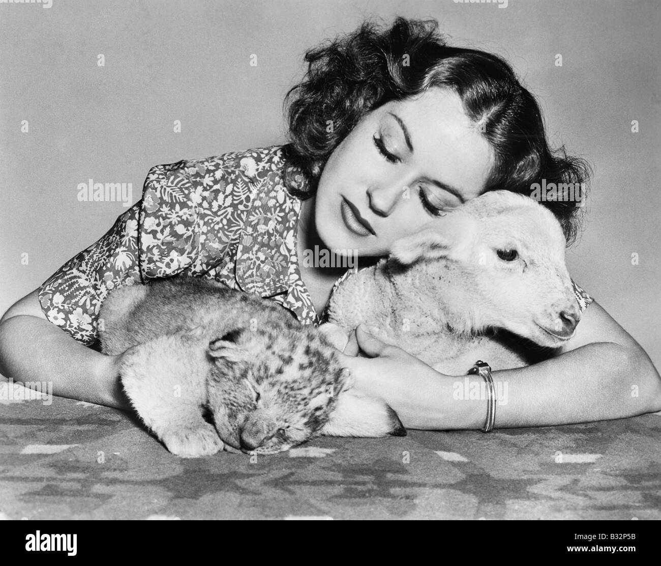 Woman with sleeping lamb and lion cub Stock Photo - Alamy