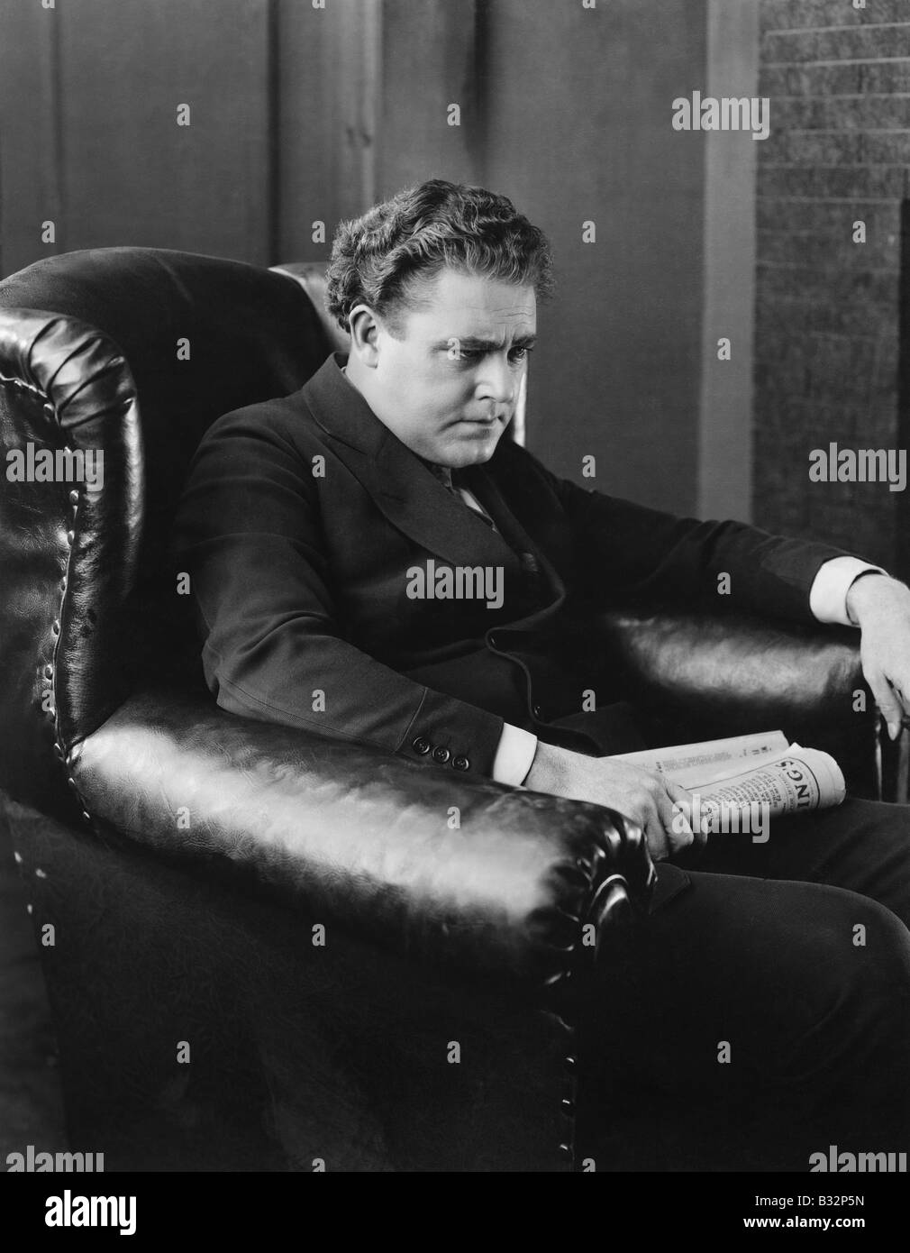 Portrait of brooding man in easy chair Stock Photo - Alamy