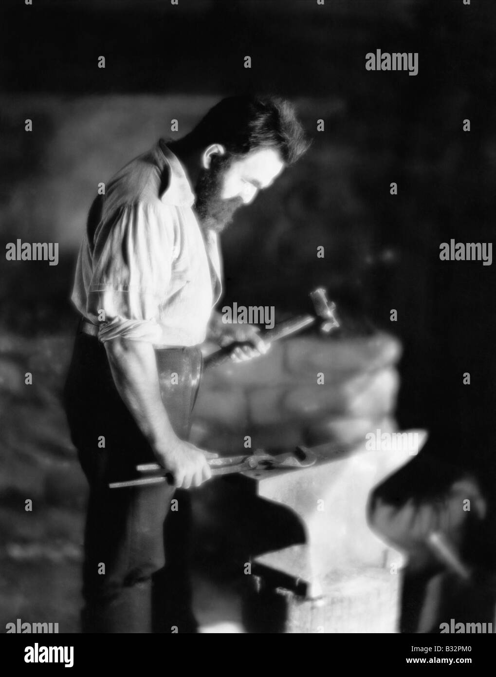 Blacksmith working metal on anvil Stock Photo - Alamy