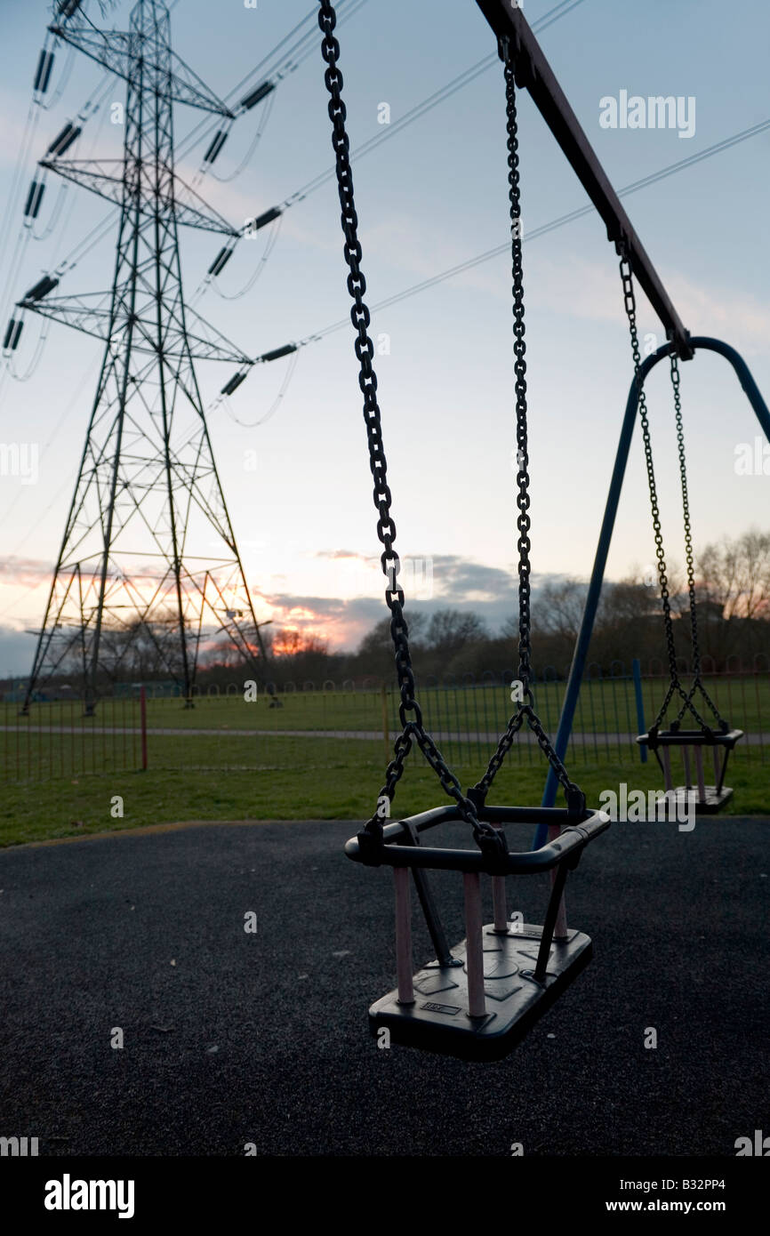 Children's urban playground swings in the shadow of an electricity ...