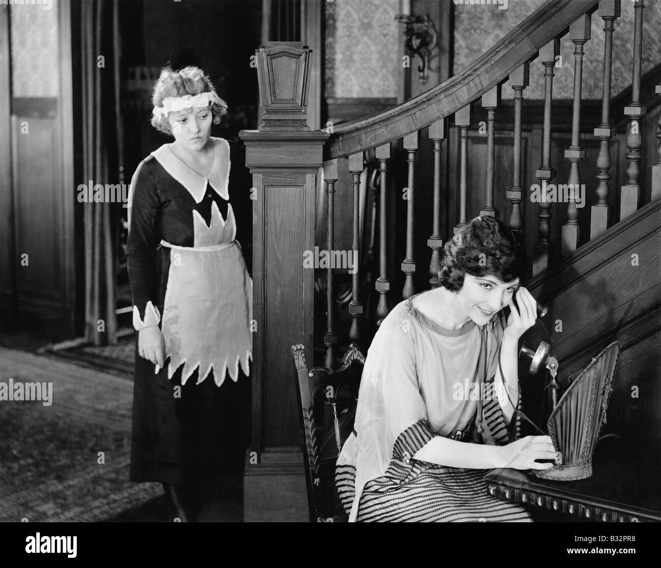 Maid eavesdropping on womans telephone call Stock Photo - Alamy