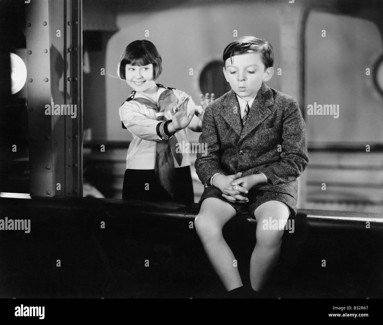Girl behind a boy pretending to push him overboard Stock Photo - Alamy