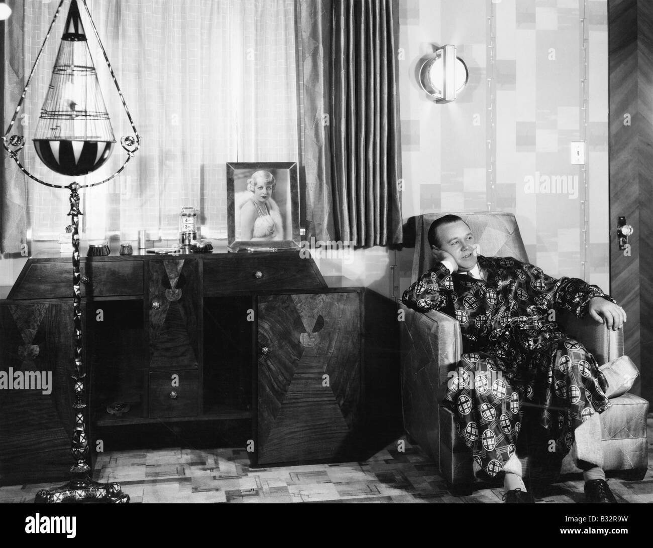 Man in a robe sitting on a chair Stock Photo - Alamy