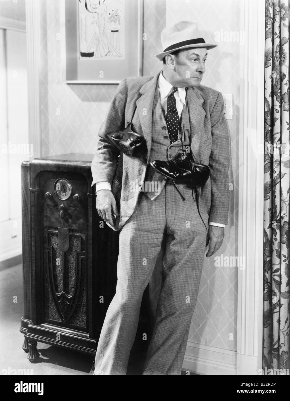 Man sneaking into the room with his shoes tied around his neck Stock ...