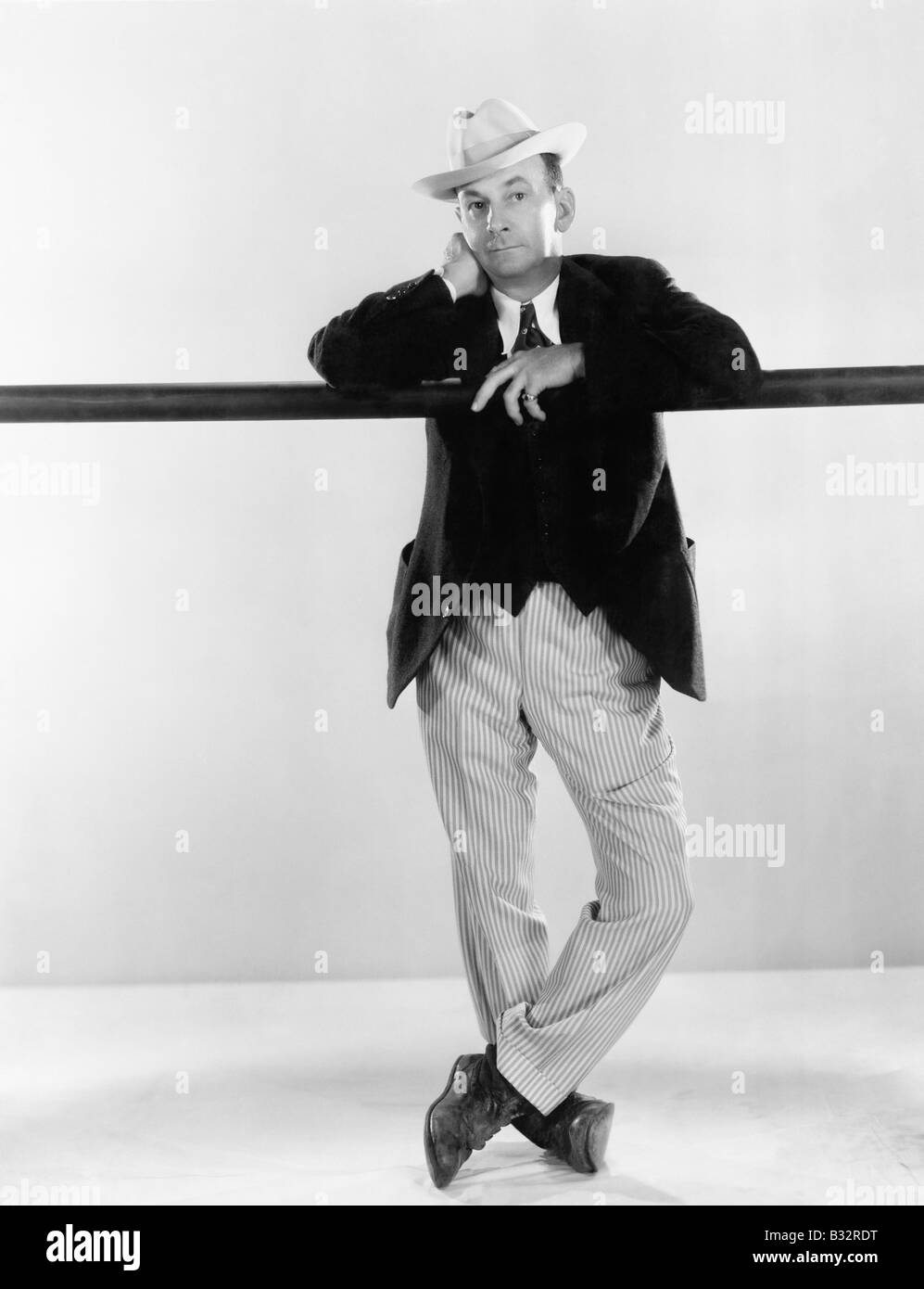 Man leaning against a balance beam Stock Photo - Alamy