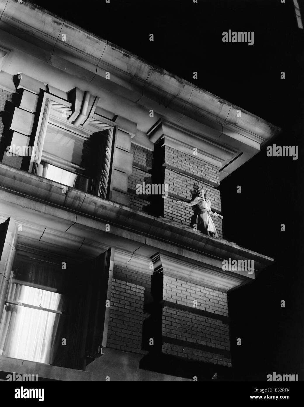 Woman standing on the top of a building on a ledge Stock Photo - Alamy