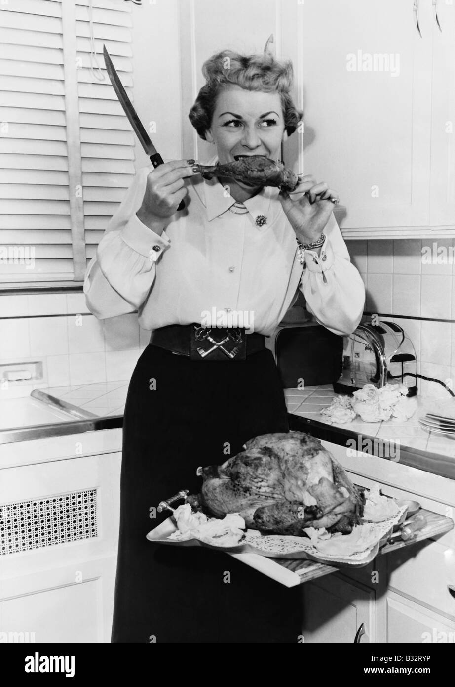 Woman eating roast turkey in her kitchen with a knife in her hand Stock ...