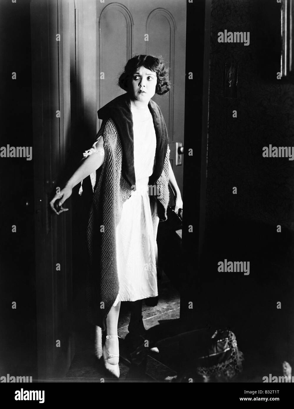 Woman opening door worried Black and White Stock Photos & Images - Alamy