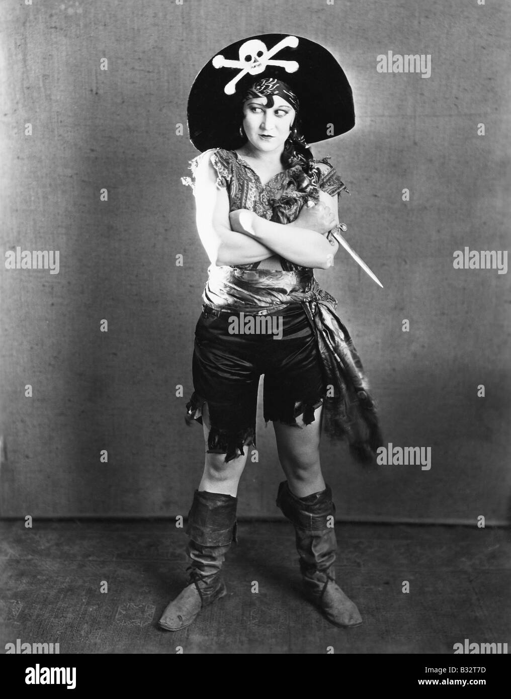 Female in a pirate's costume standing with her arms crossed and holding ...