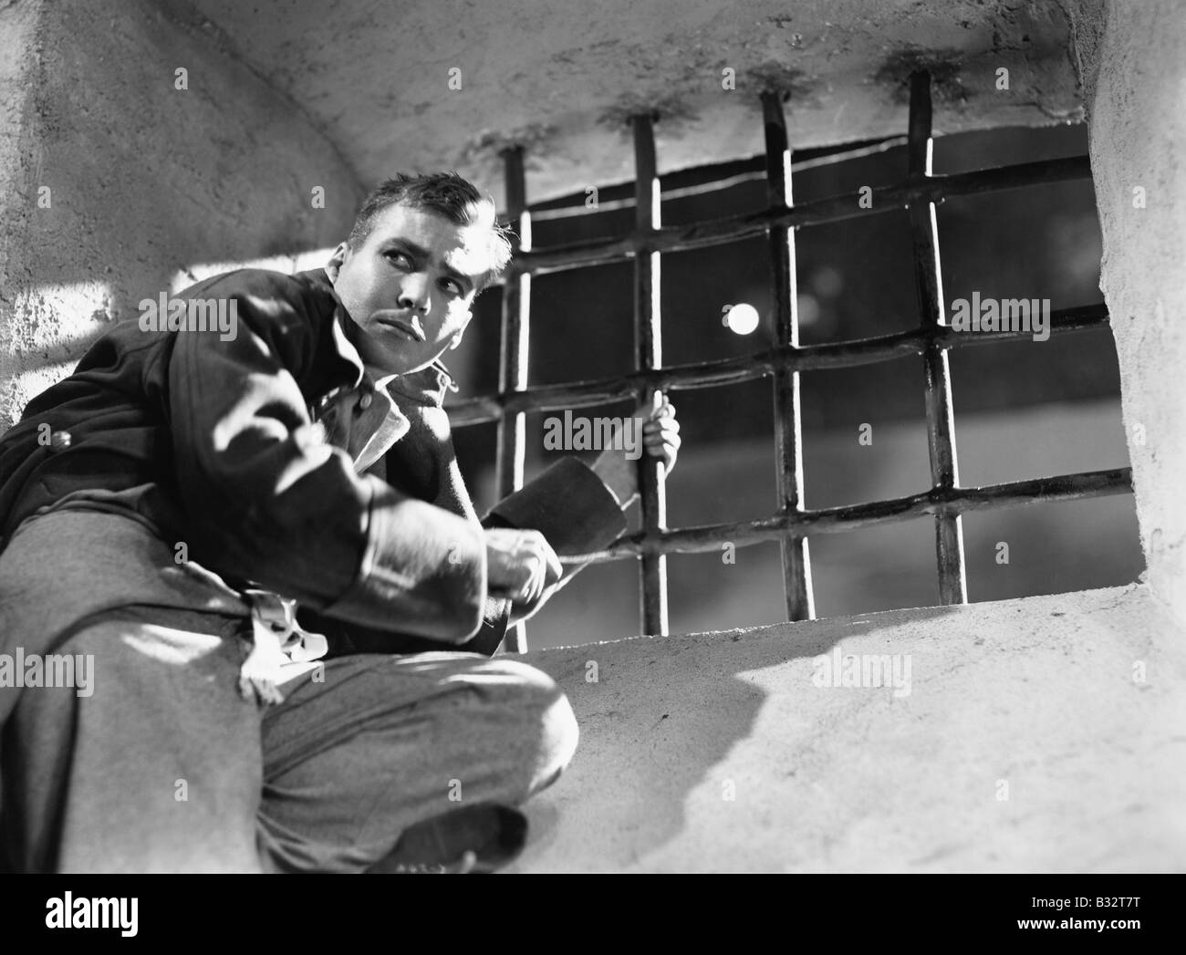 Low angle view of a young man trying to escape from a prison cell Stock ...