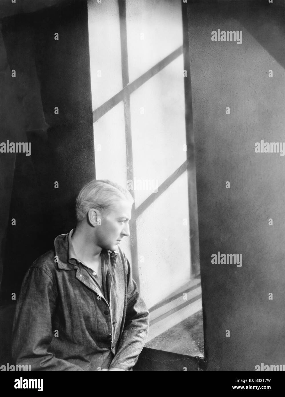 Young man looking through a window Stock Photo - Alamy