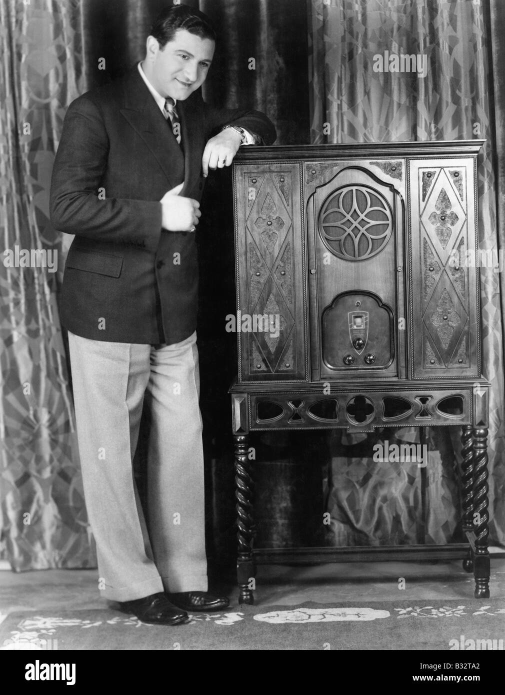 Young man standing near a radio and smiling Stock Photo - Alamy