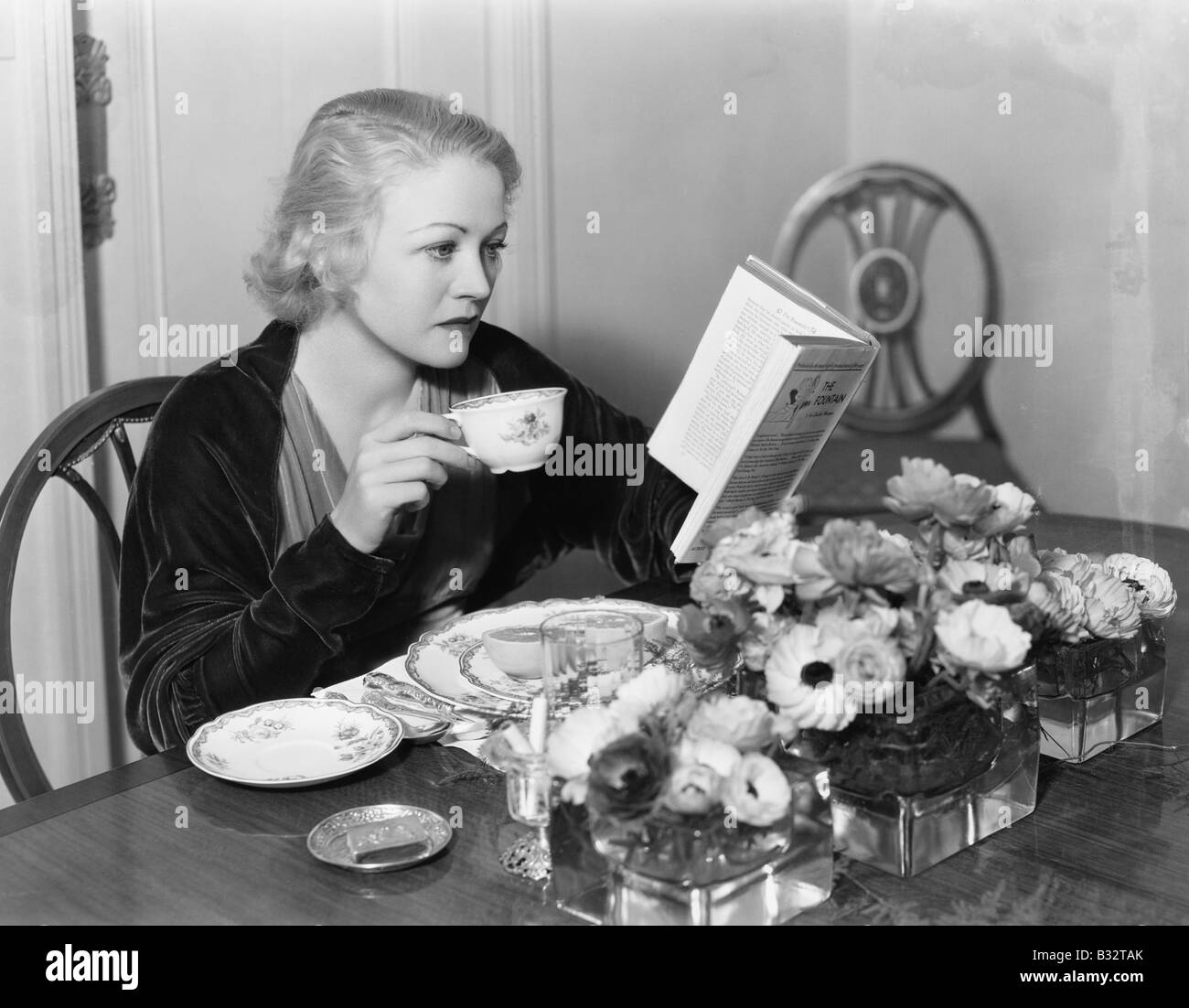Young woman sitting dining table Black and White Stock Photos & Images ...